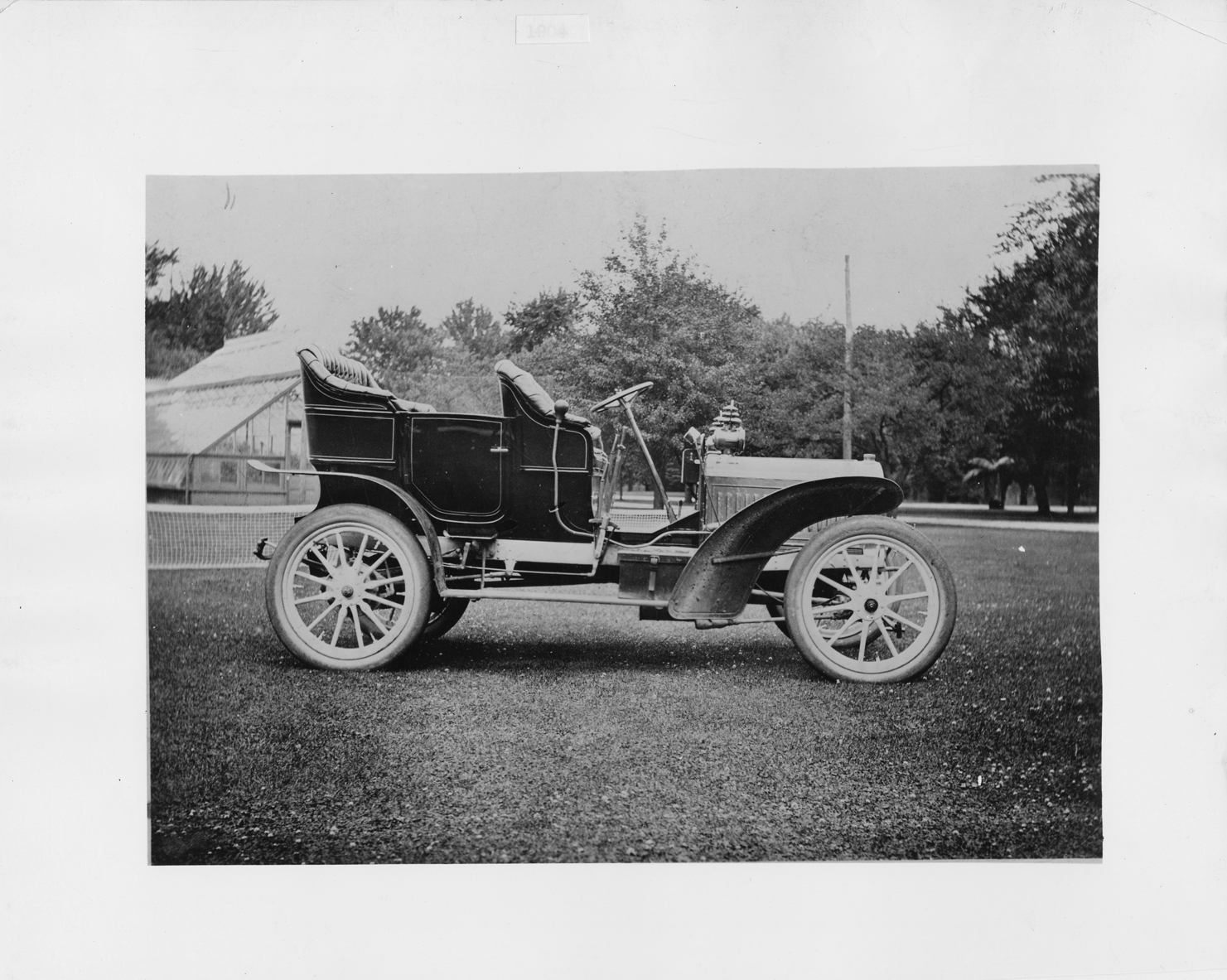 1905 Packard Model N, right side view with greenhouse in background ...