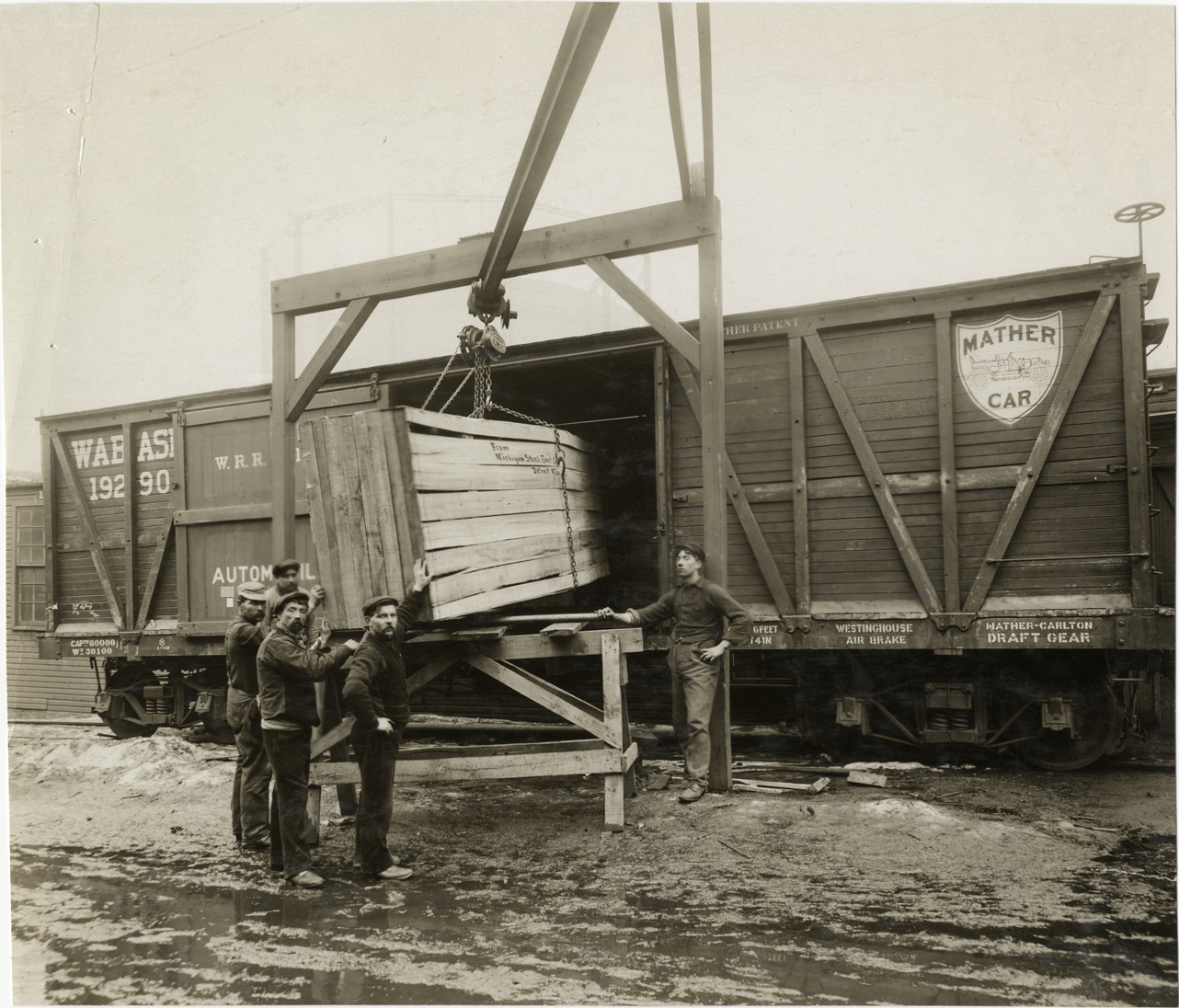 Workers loading crate into railroad car, Michigan Steel Boat Company ...