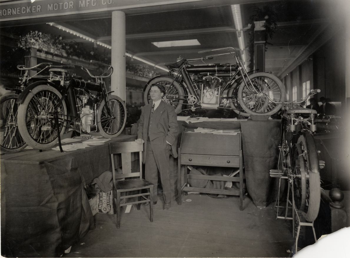 Man posing with motorcycles in Hornecker Motor Manufacturing Company ...