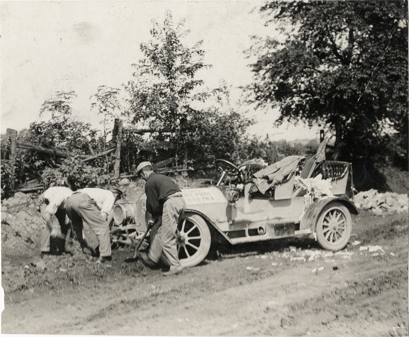 Motorists digging in front of pilot automobile on roadside, 1908 ...