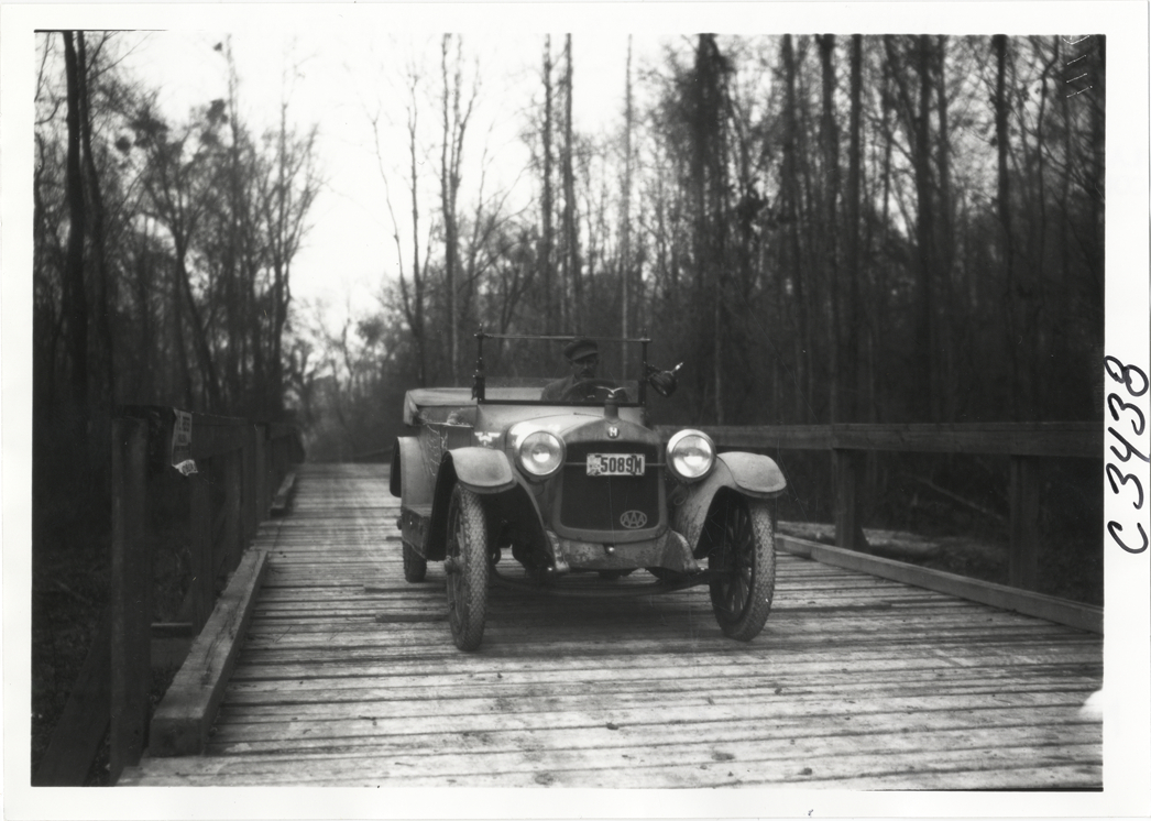 Driver in Hupmobile automobile crossing bridge, Hupmobile United ...
