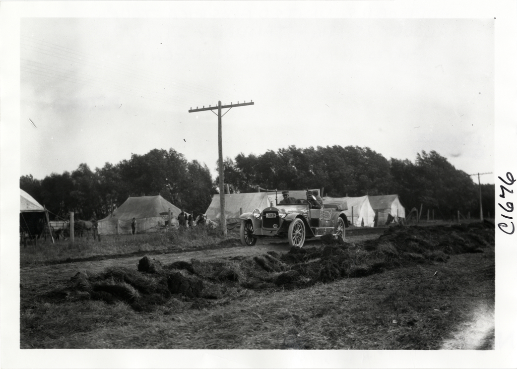 Motorists in Hupmobile traveling past tents on roadside, Hupmobile ...