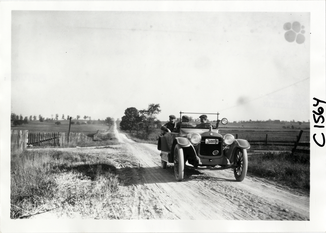 Motorists in Hupmobile automobile traveling on rural road to Cincinnati ...