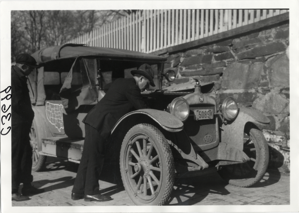 Motorist looking under hood of Hupmobile automobile, Hupmobile United ...