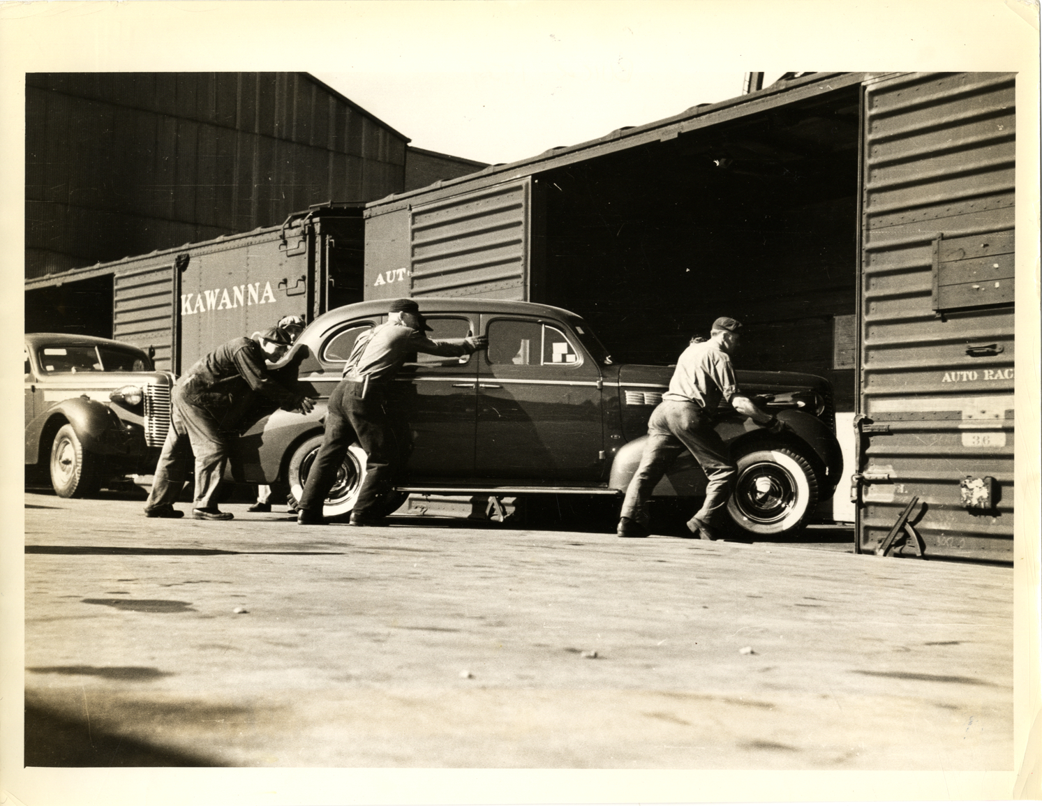 Men loading Buick automobiles onto a freight car | DPL DAMS